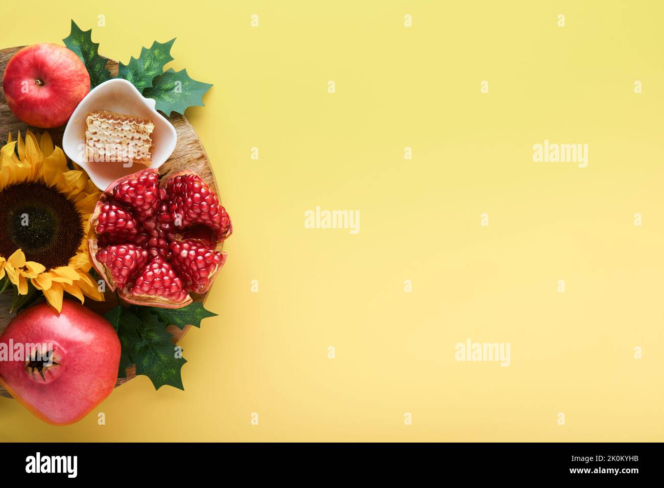 Rosh Hashanah. Ripe pomegranate, apple, honey and sunflower, yellow ...