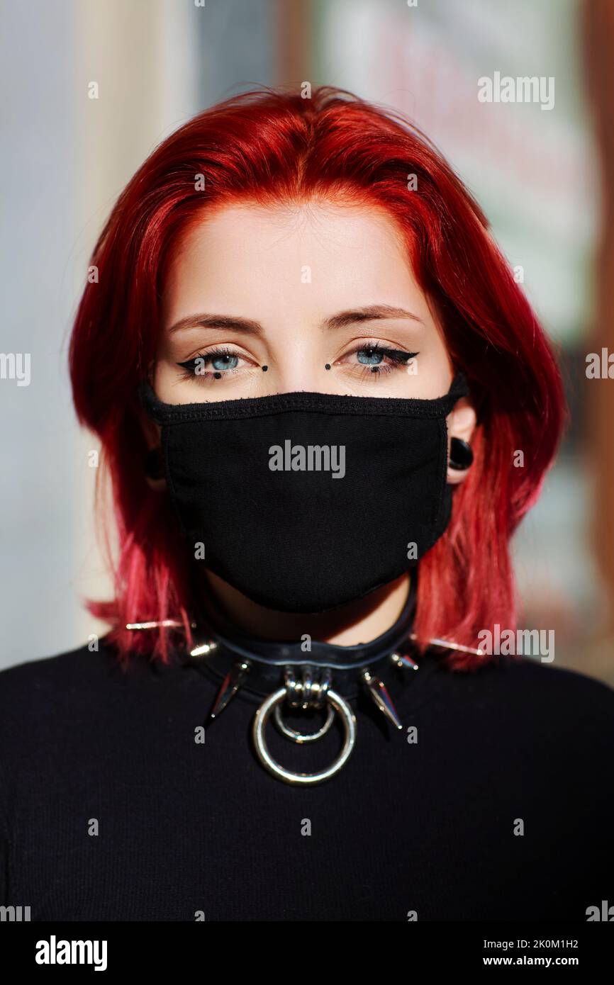 close up young adult woman outside with face mask blue eyes with punk ...