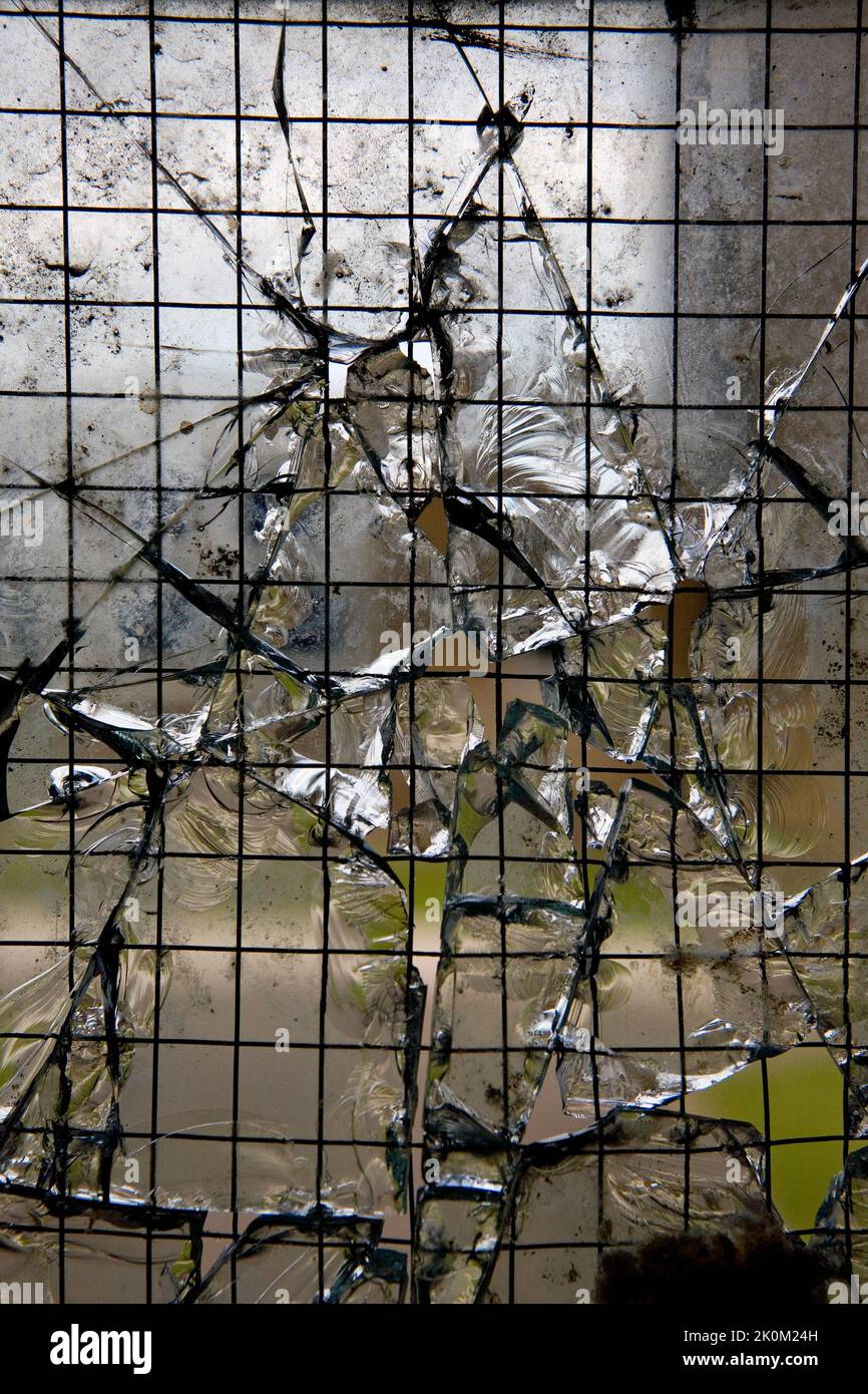 A smashed window pane in a neglected inner city school Stock Photo - Alamy