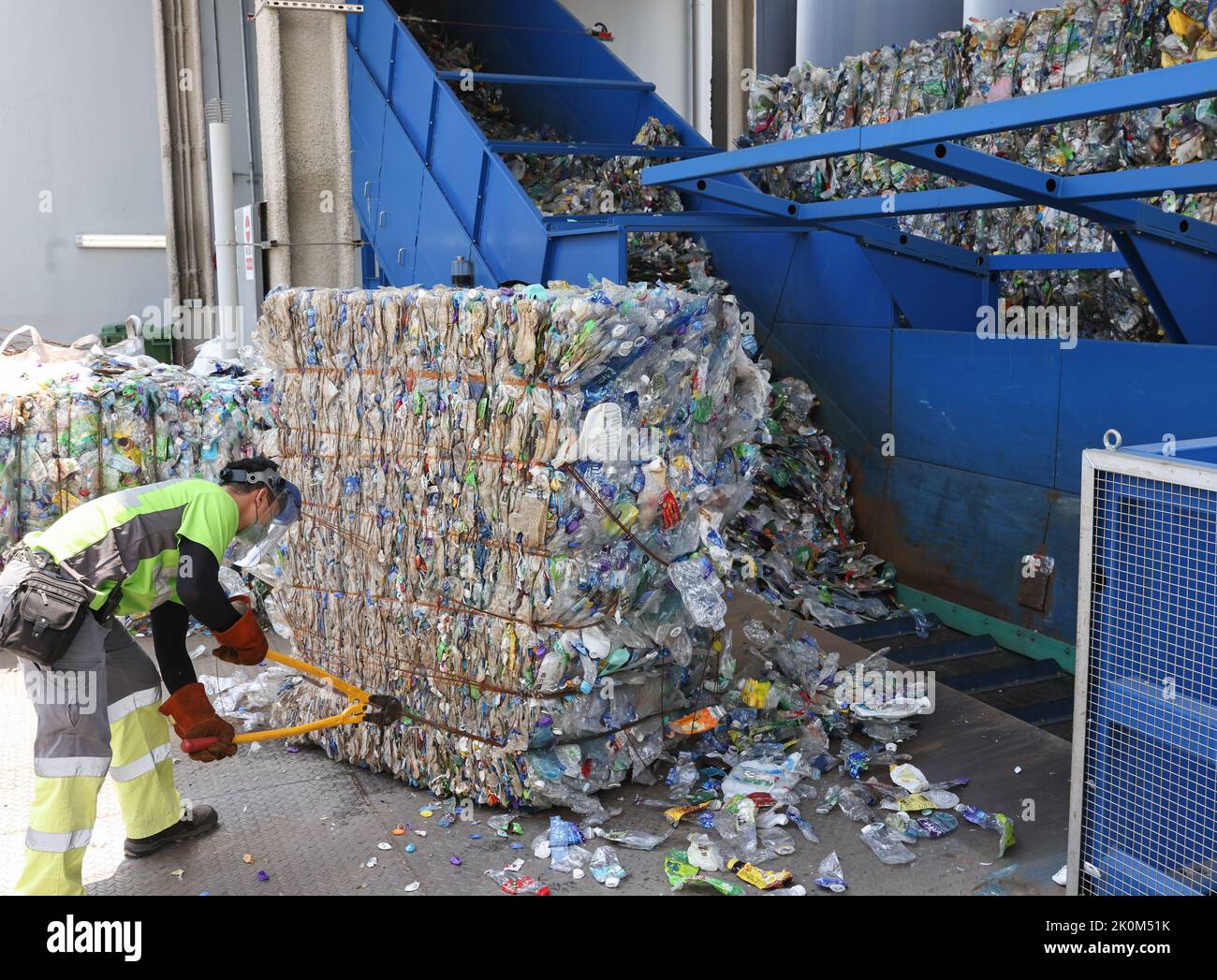 A worker transfer recycling plastic bottles to a bale breaker at New ...