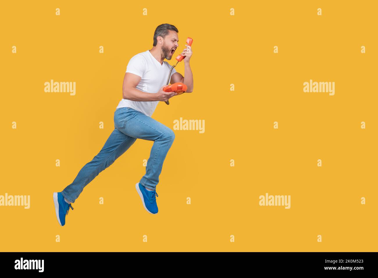 angry man shouting with telephone call. man call isolated on yellow ...