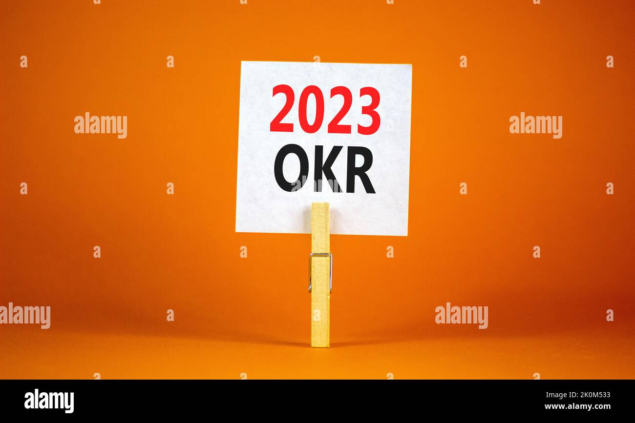 OKR objectives and key results symbol. White paper, words OKR 2023 clip on wooden clothespin ...