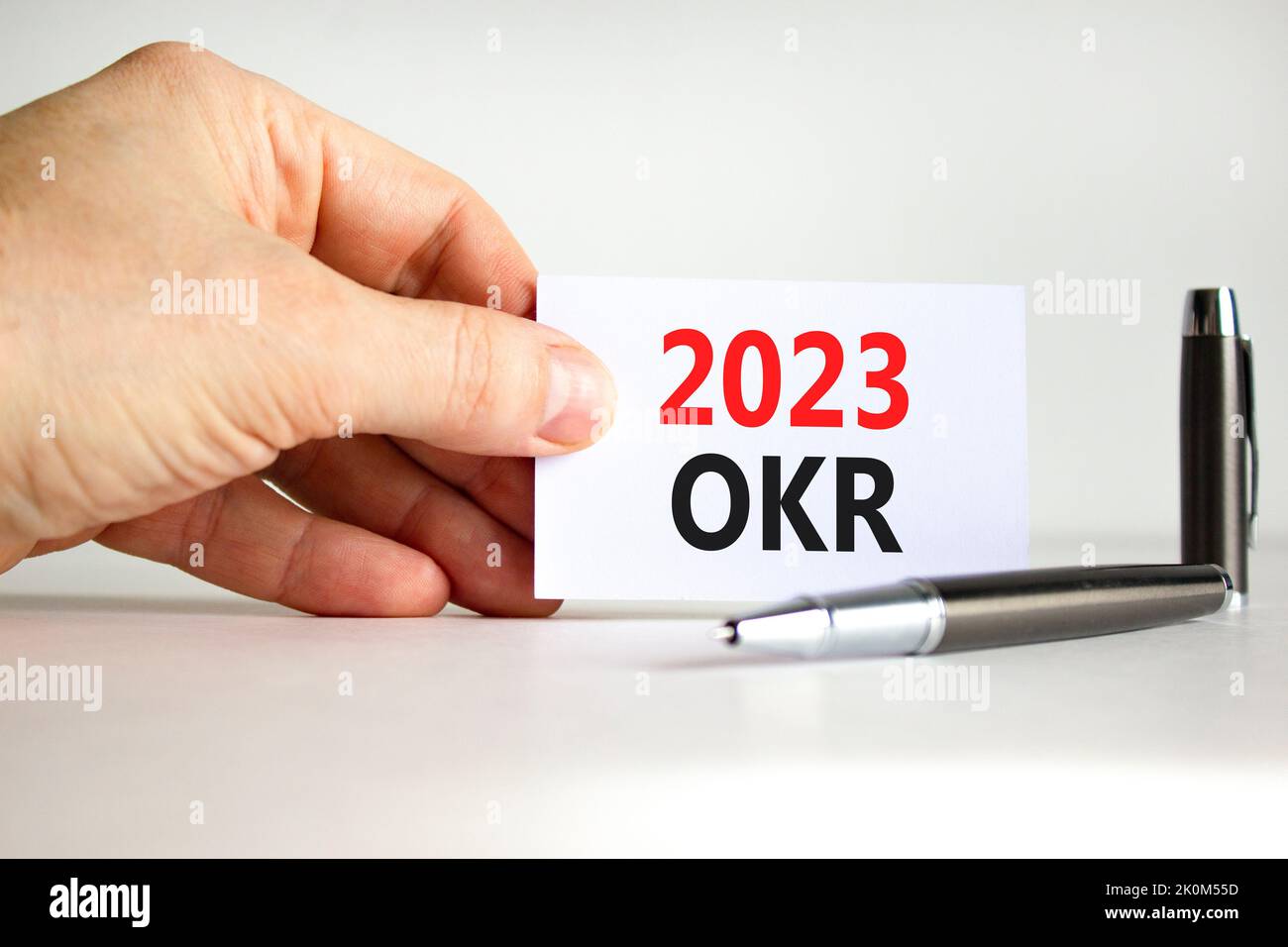 OKR objectives and key results symbol. White paper with words OKR 2023. Businessman hand ...