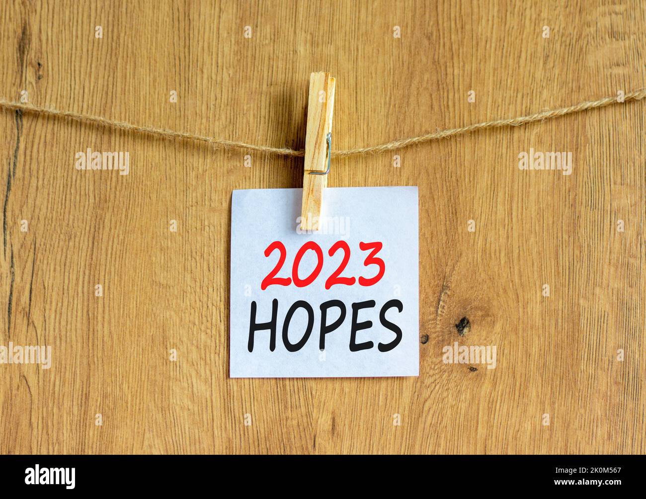 2023 Hopes symbol. White paper with words 2023 Hopes, clip on wooden ...