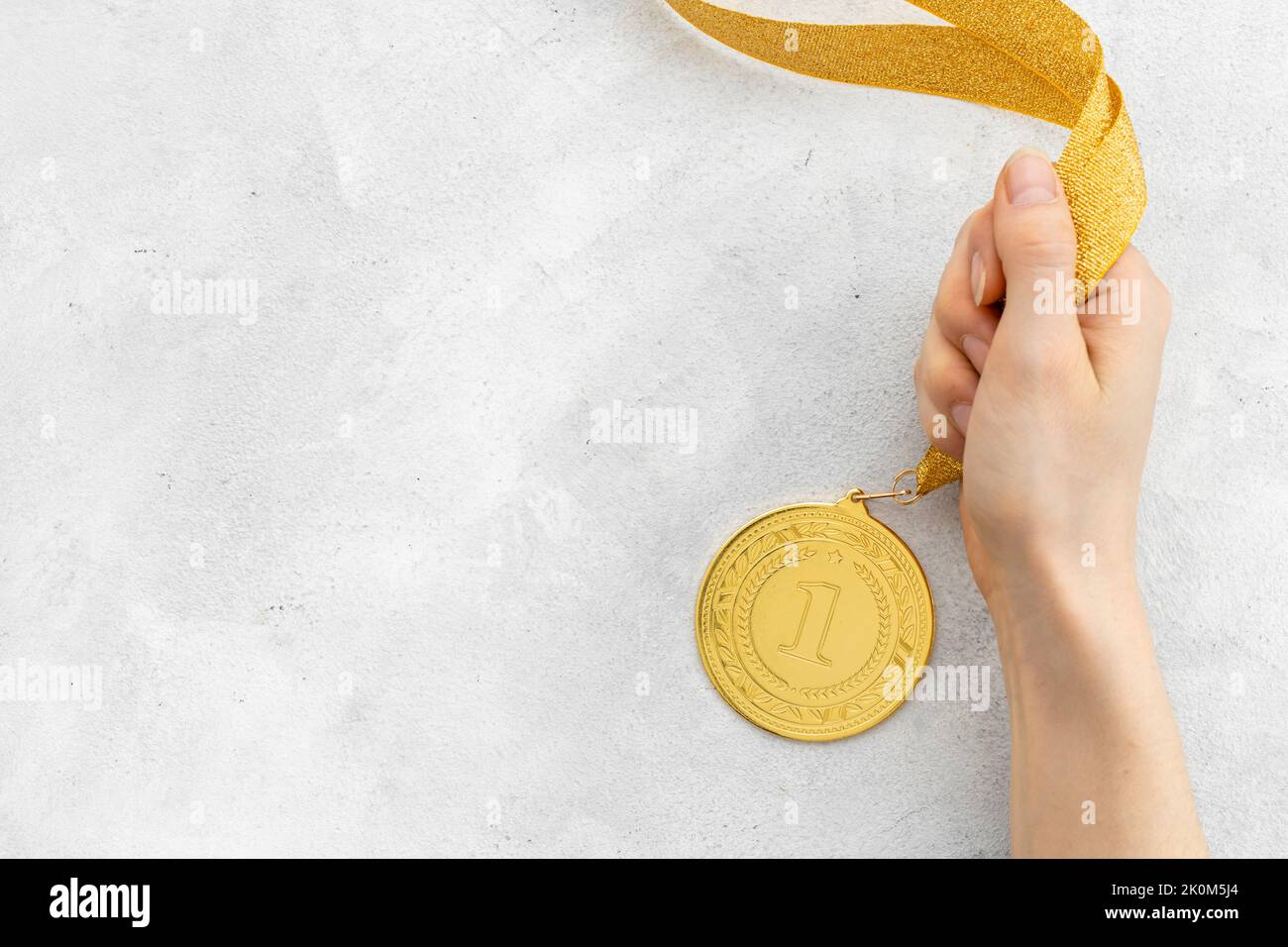 Winner and success concept. Hand holds gold medal trophy Stock Photo ...