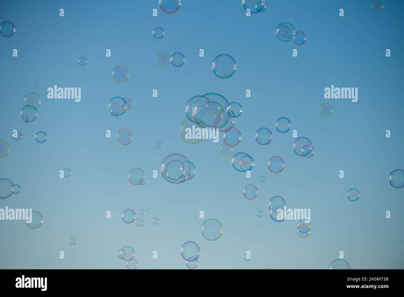 Big bubble flying over blue sky. Huge colorful soap bubbles fly over ...