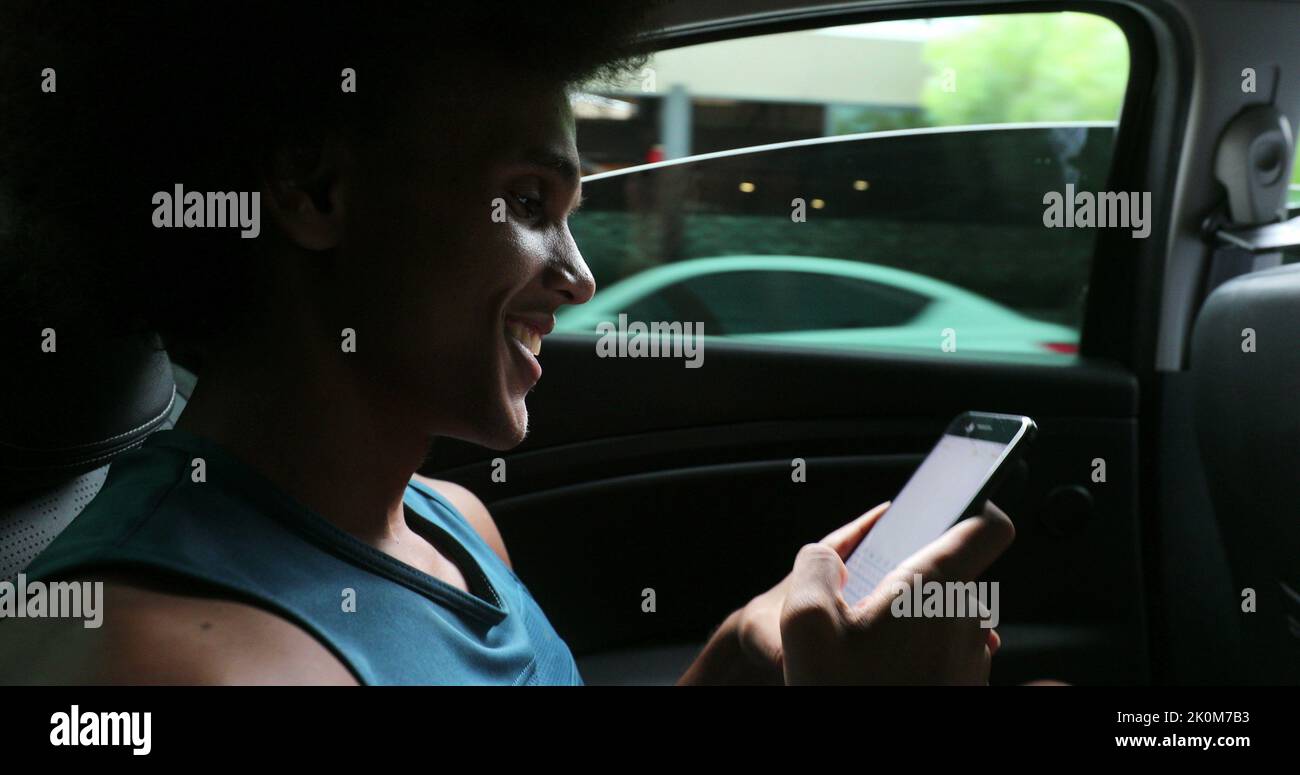Happy passenger looking at cellphone screen while riding cab Stock ...
