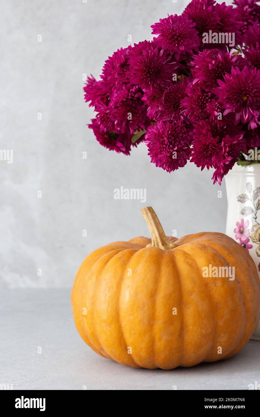 Close-up brown pumpkin with a bouquet of chrysanthemum on the table ...