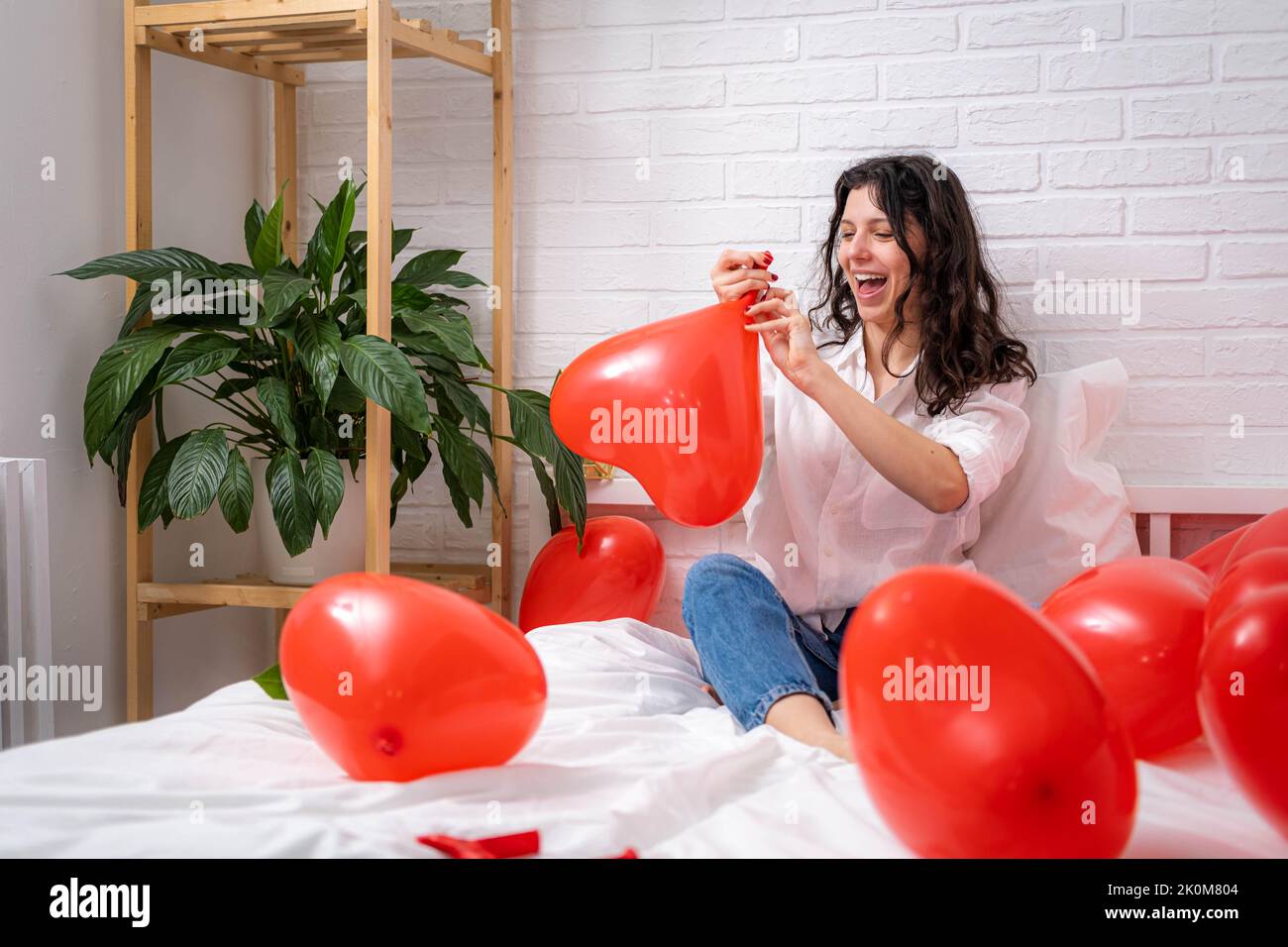 Girl Is Blowing Air Balloon At Home Handsome Brunette Girl Inflating Red Heart Shaped Balloon
