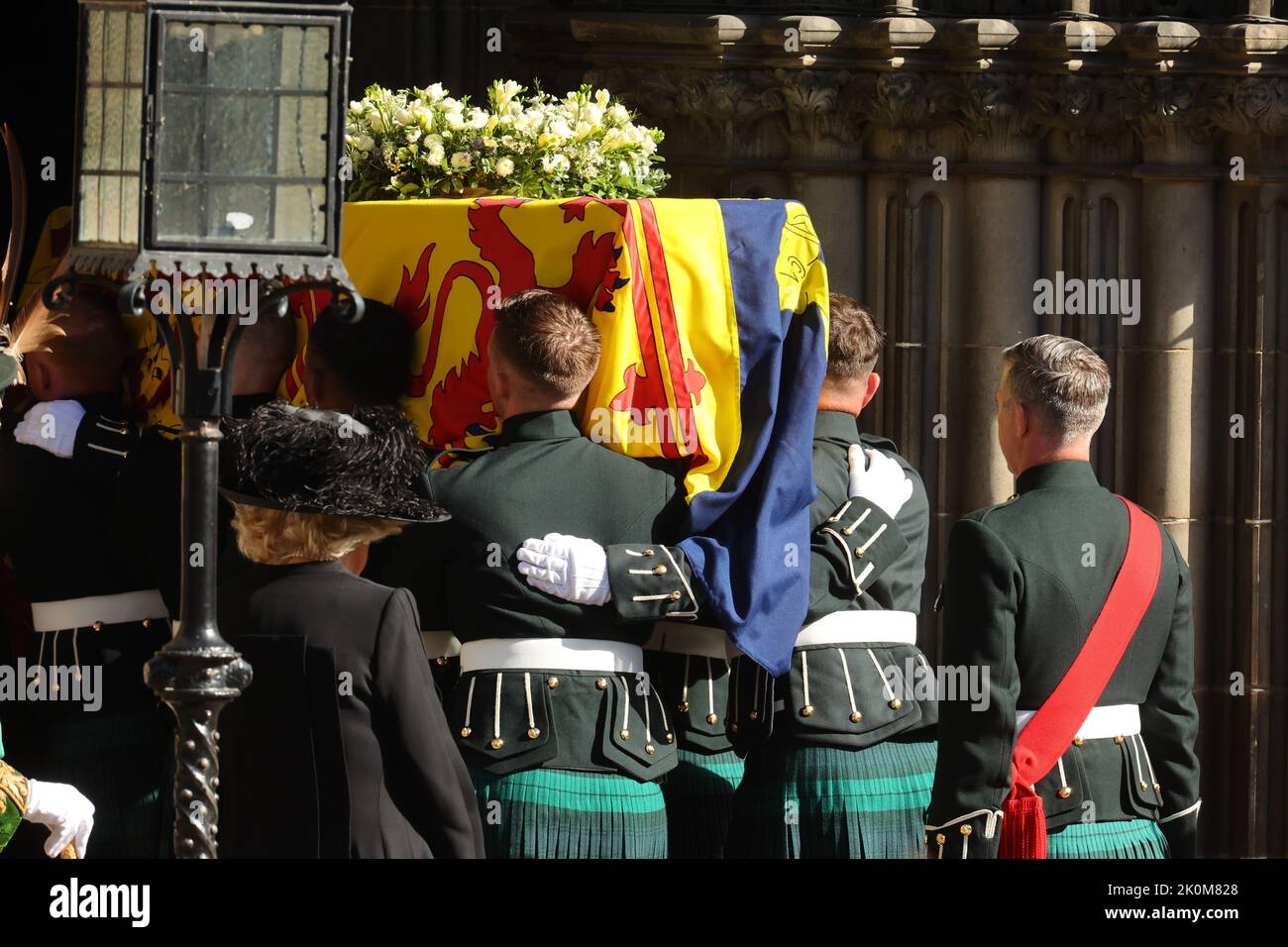 The Queen Consort (left) watches as royal guards carry Queen Elizabeth ...