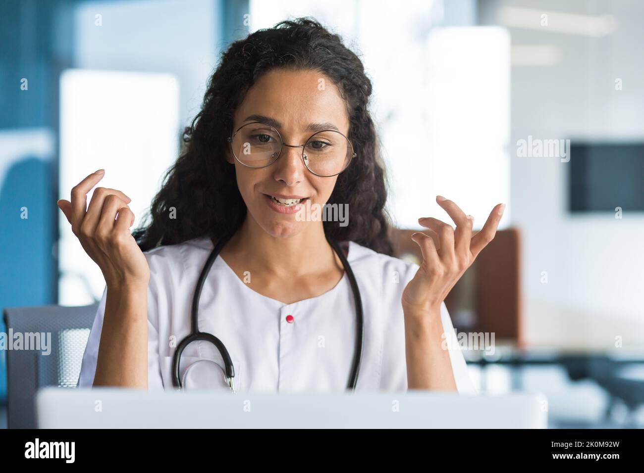 Close-up photo of young hispanic female doctor talking to patient and ...