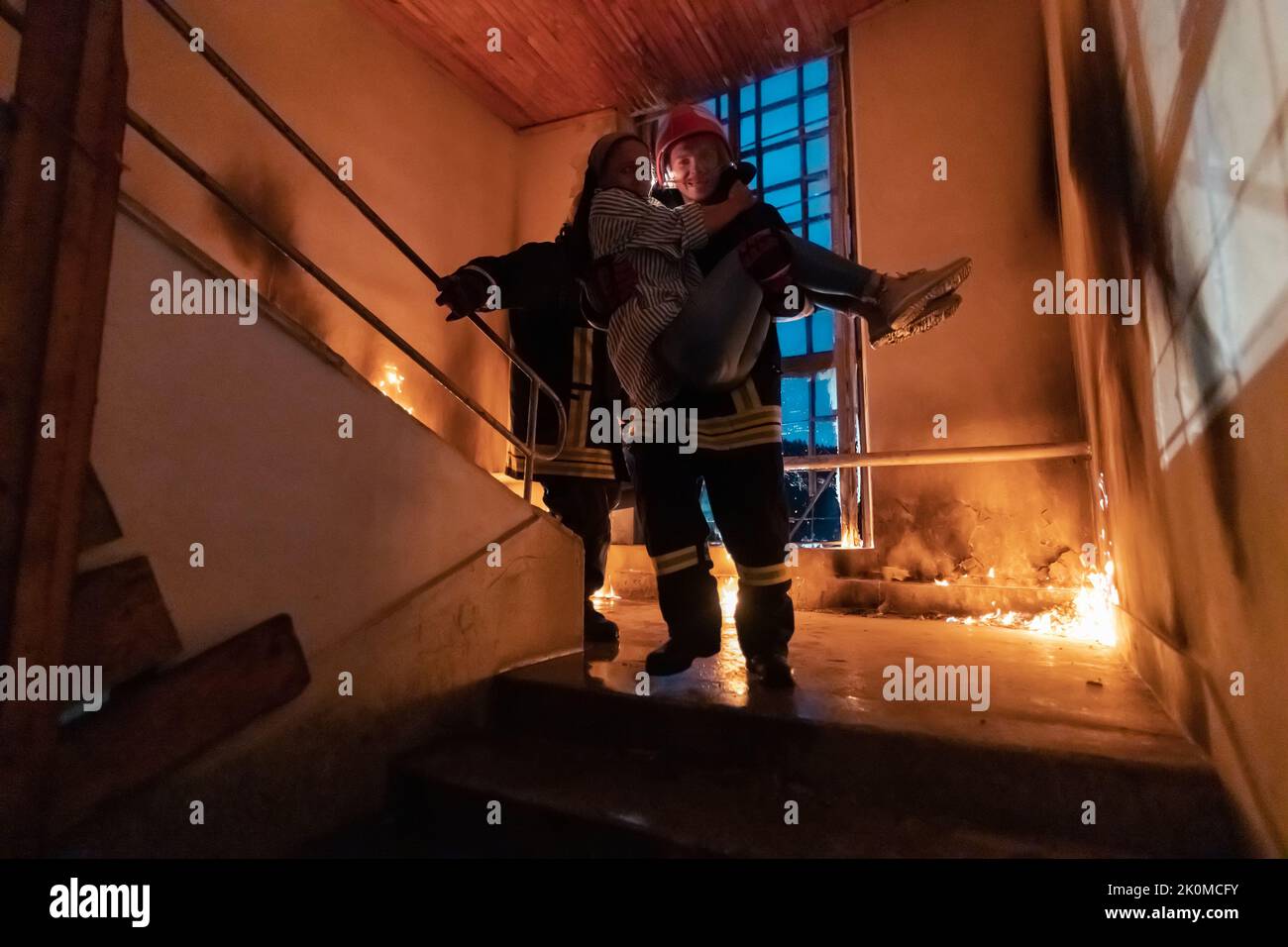 Brave Fireman Descends Stairs of a Burning Building and Holds Saved ...