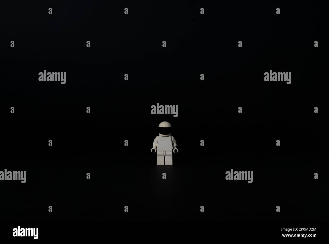 toy astronaut falling into the void in the middle of the black space ...