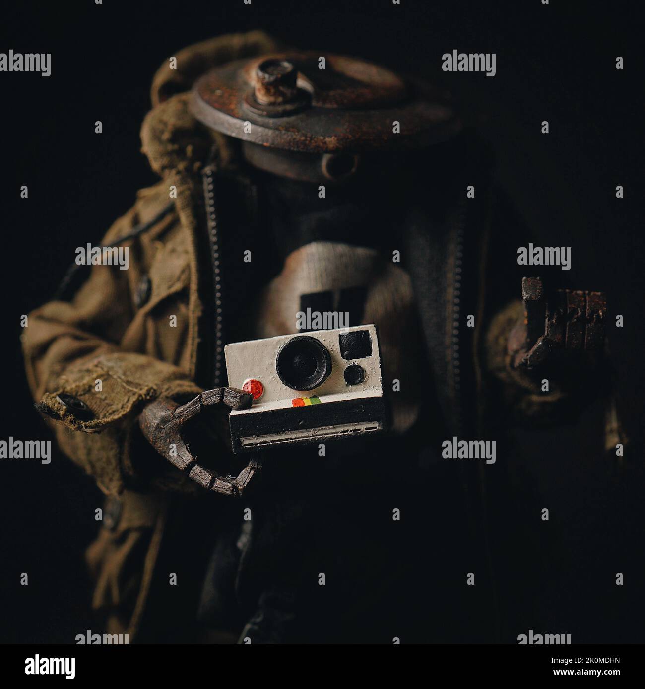 A closeup shot of a headless soldier miniature holding an old camera ...