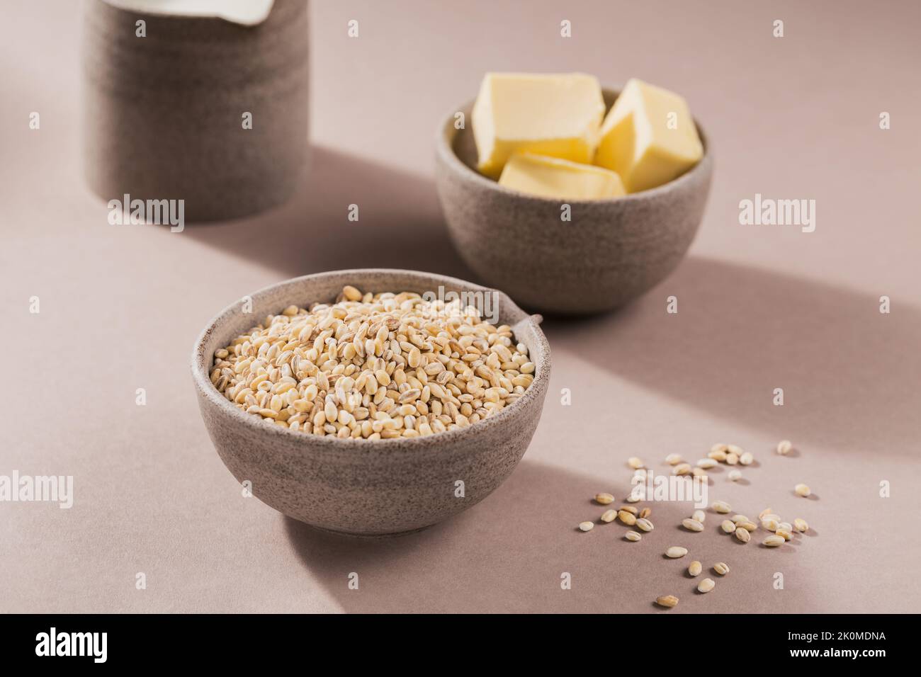 Bowl of dry raw broken pearl barley cereal grain with butter Stock ...