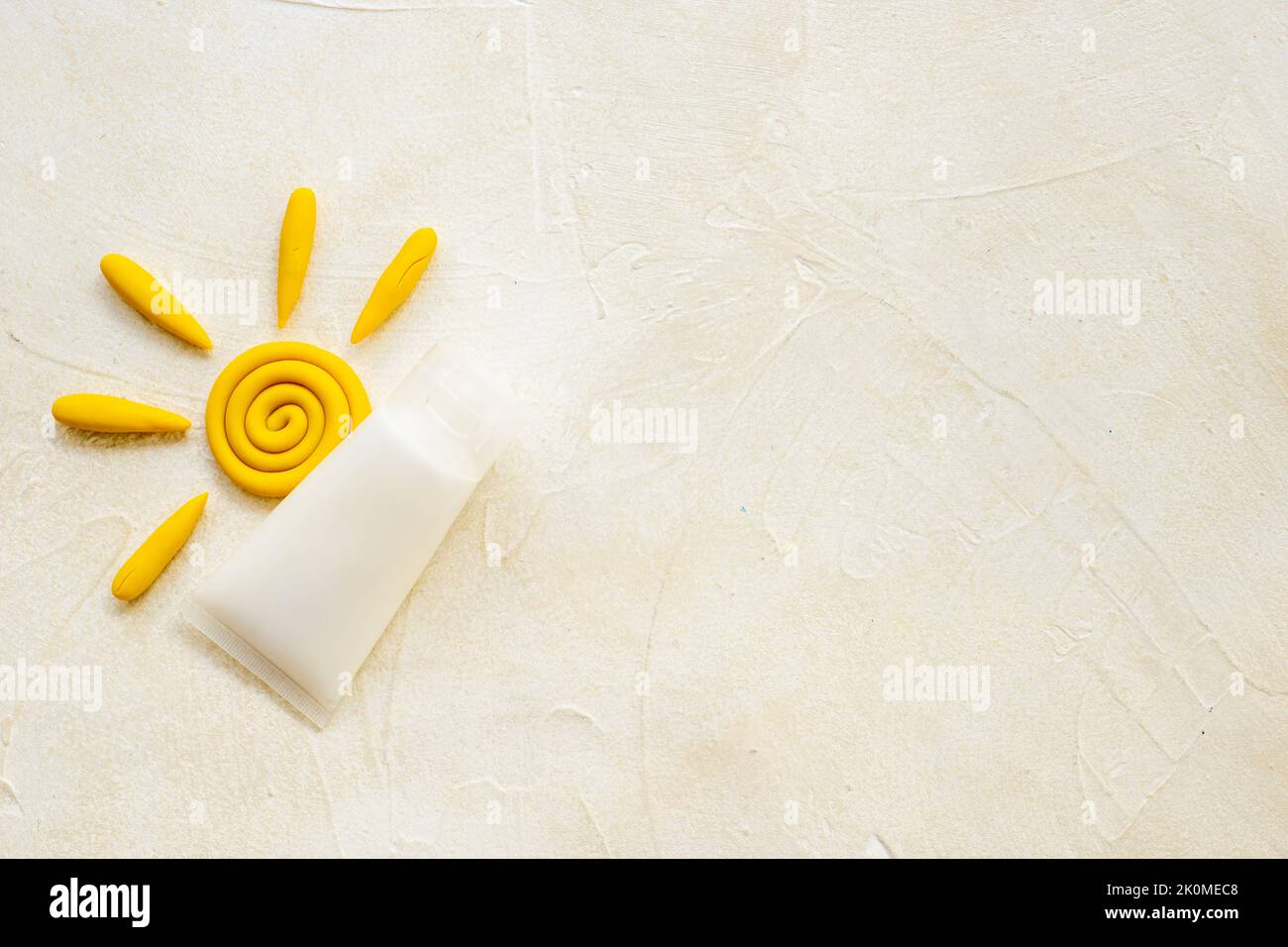 White tube with lotion and sun made of plasticine. Summer skin care ...