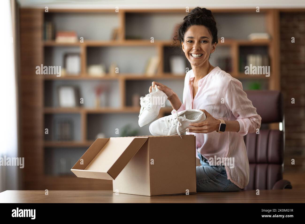 Happy pretty lady customer checking her delivery Stock Photo - Alamy