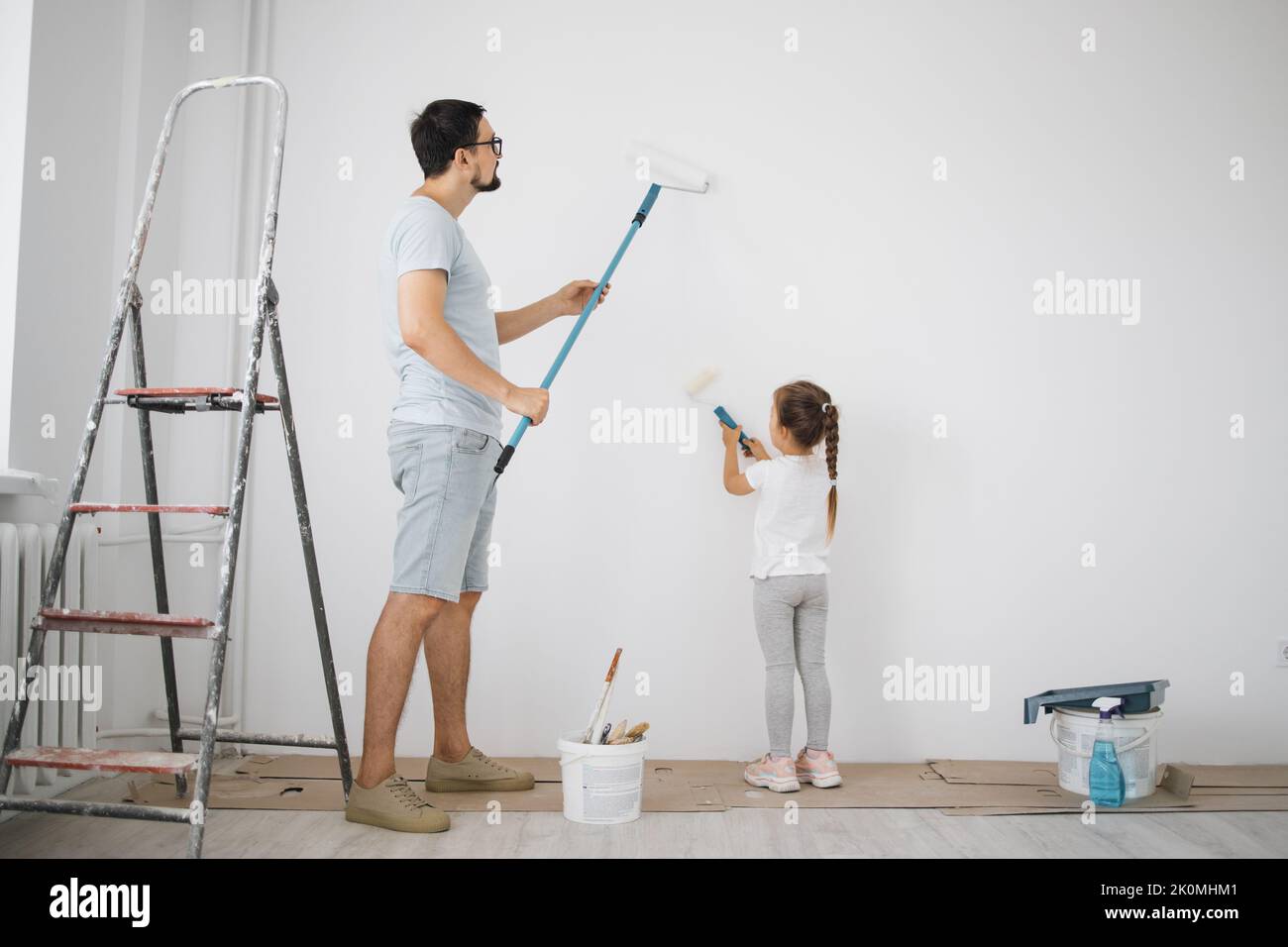 Happy attractive young father and cute little daughter makes repairs at ...