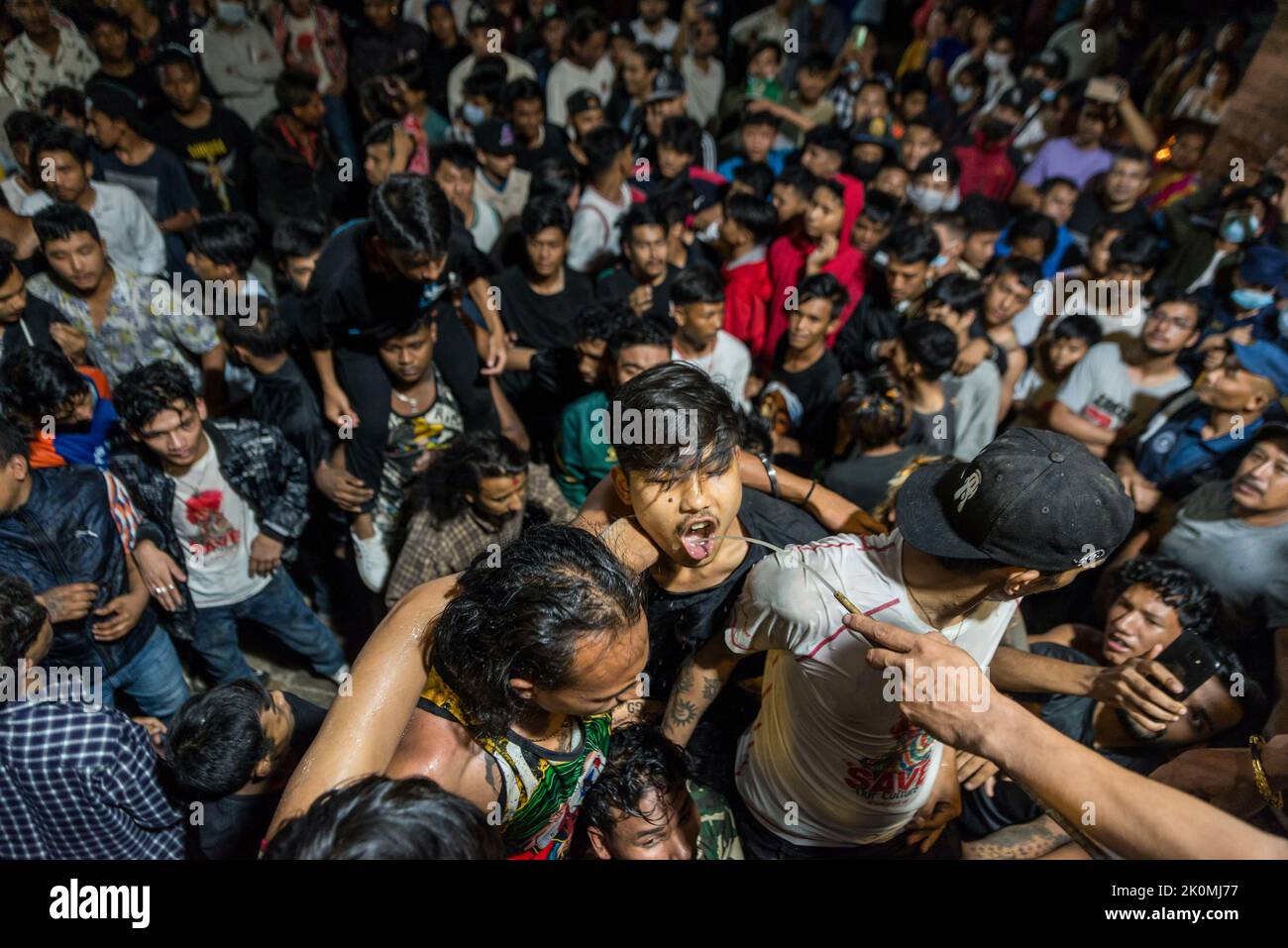 Hindu devotees struggle to drink wine as an offering from the statue of ...