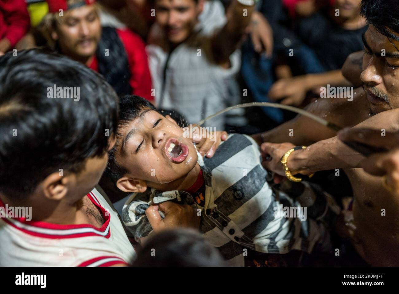 Hindu devotees struggle to drink wine as an offering from the statue of ...