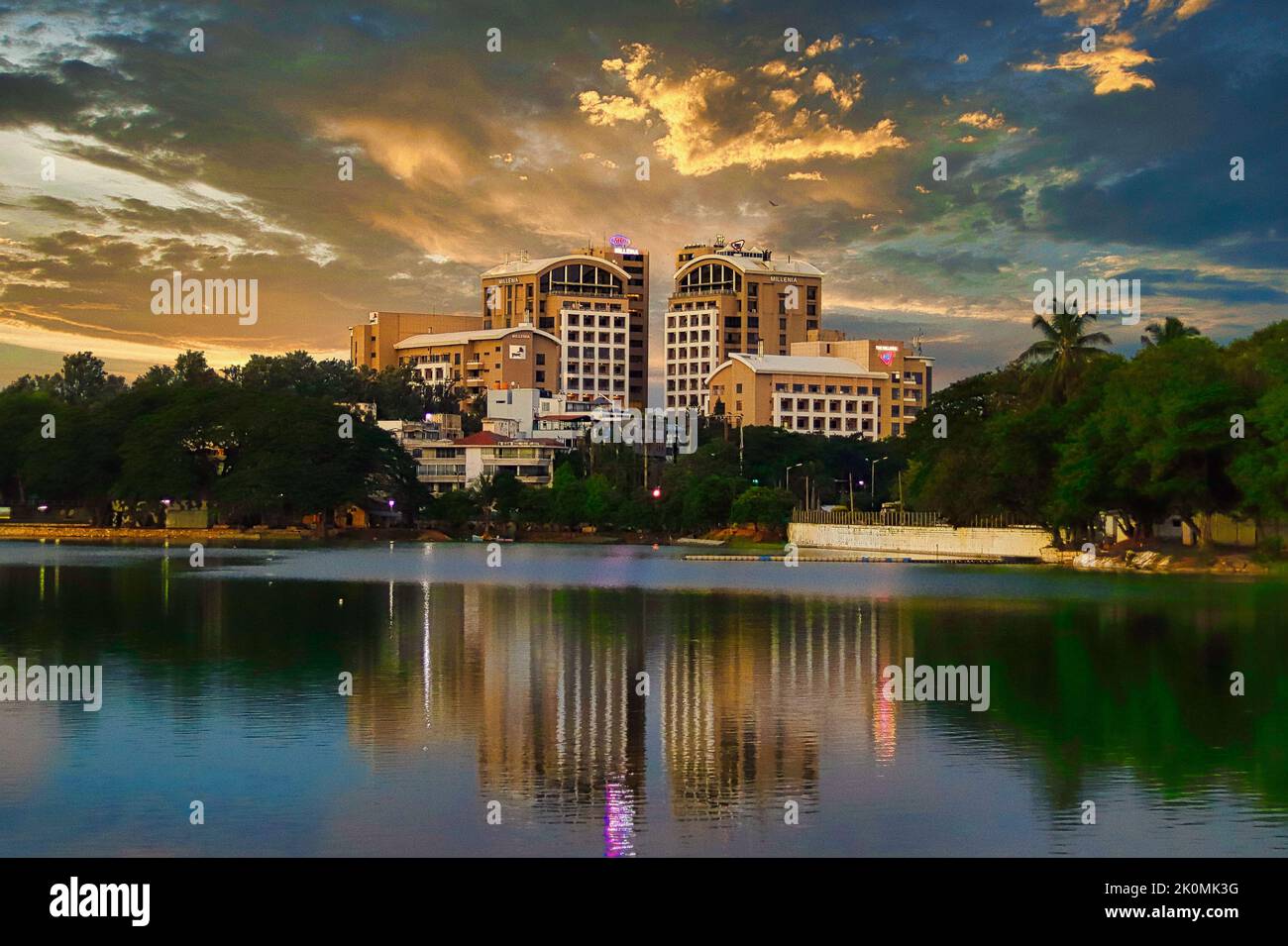 A beautiful modern building and green trees at the shore of Ulsoor Lake ...