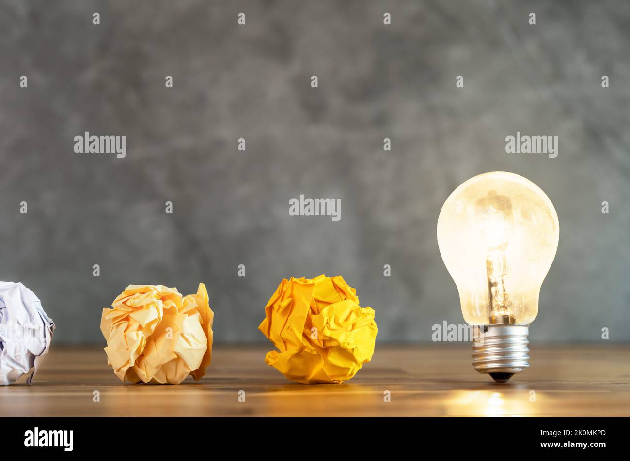 Close up photo of crumbled colorful paper and light bulb in the same ...