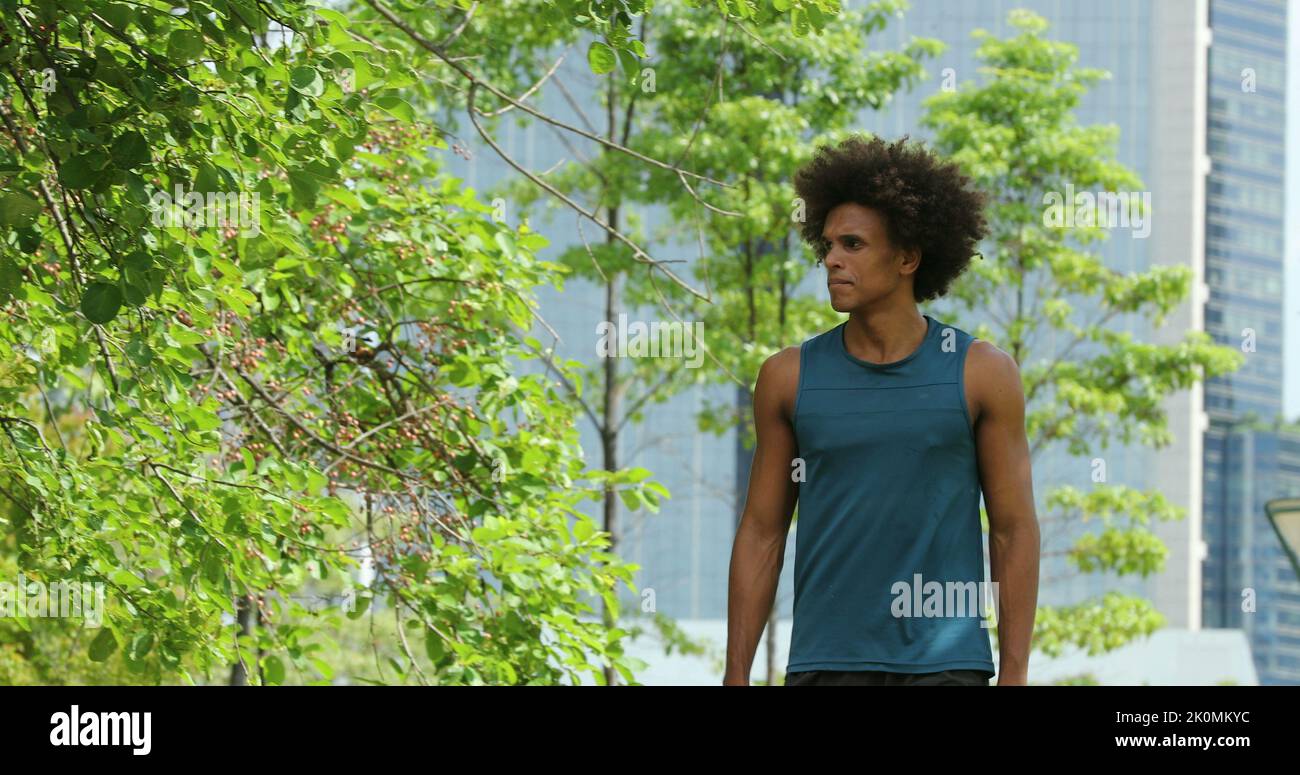 Sportive young black african man walking at park Stock Photo - Alamy