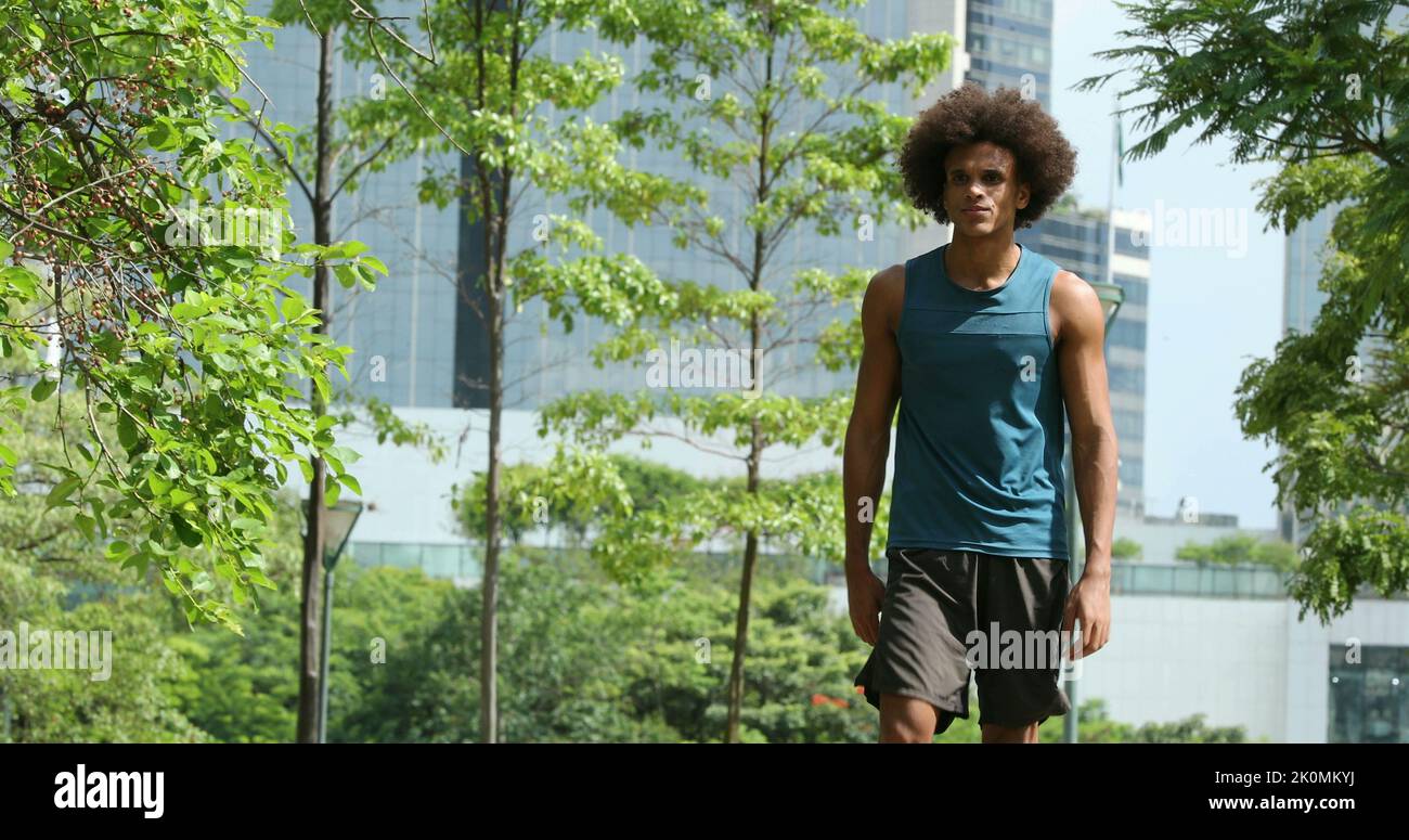 Sportive young black african man walking at park Stock Photo - Alamy