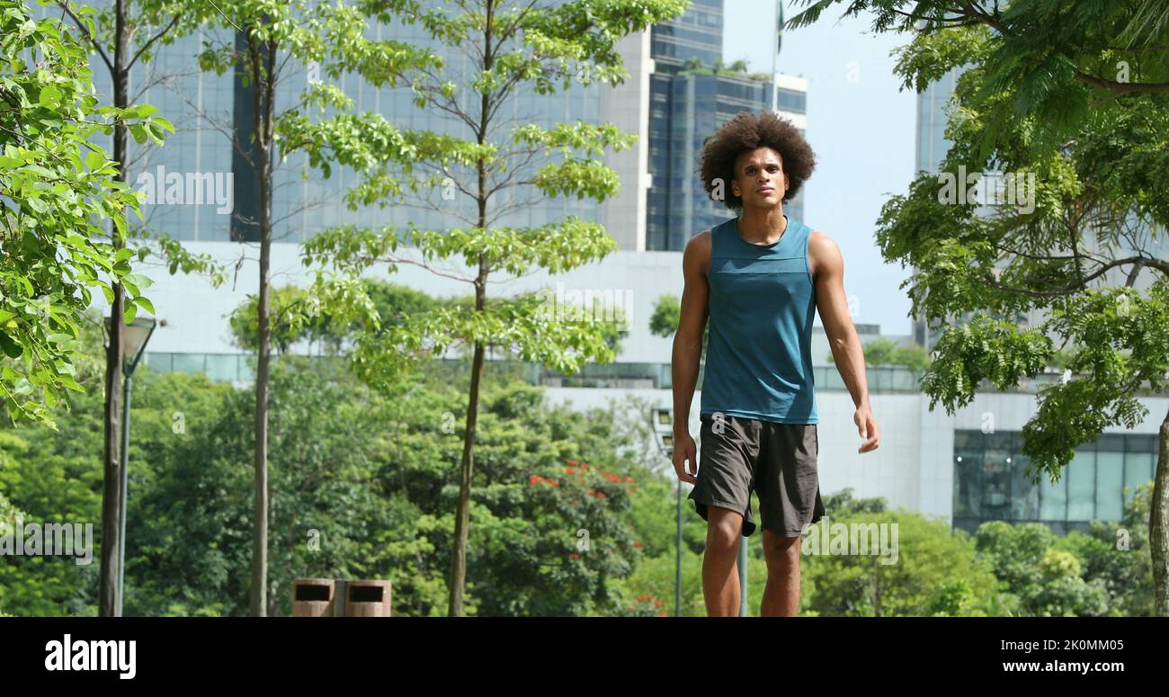 Sportive young black african man walking at park Stock Photo - Alamy