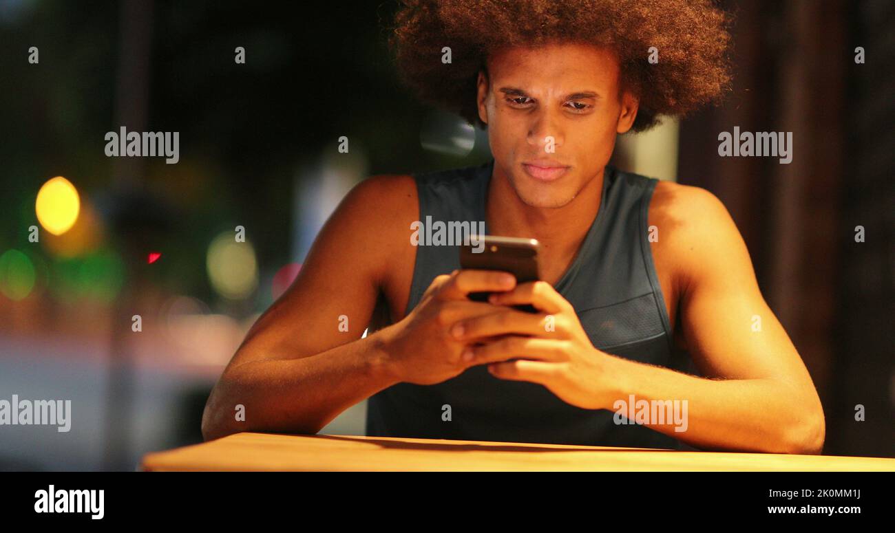 Upset african man looking at cellphone with surprise and disbelief ...