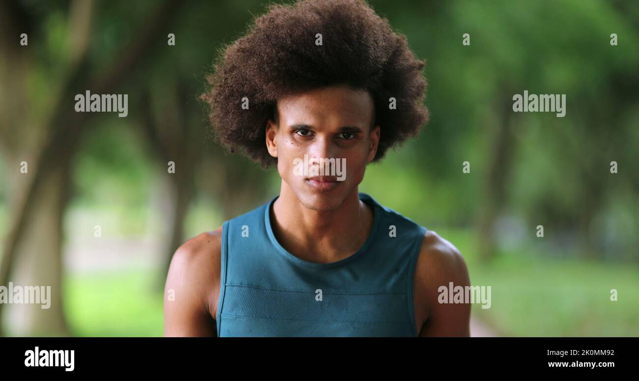 Portrait of handsome young black african man walking forward at park ...