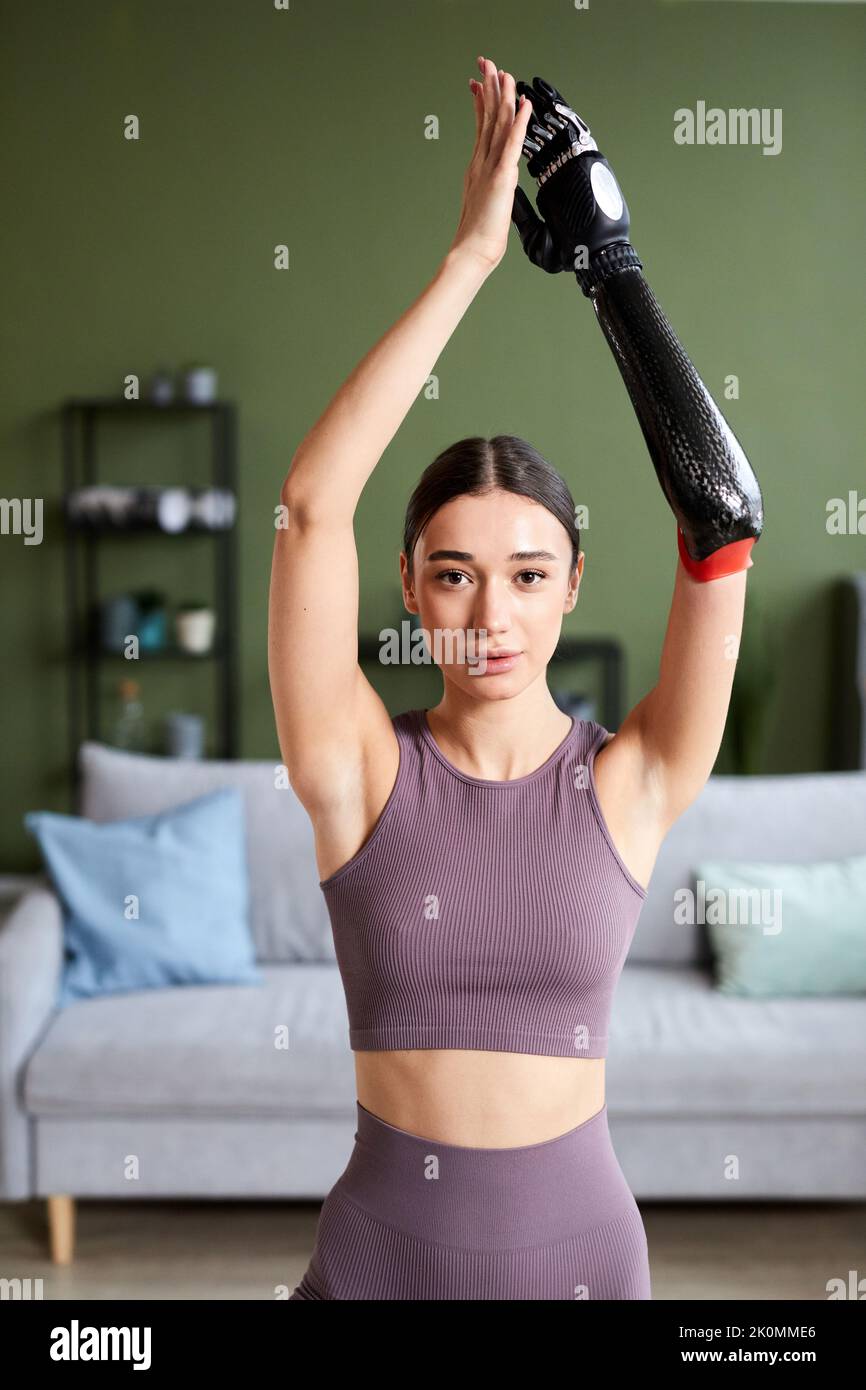 Portrait of young healthy girl stretching her arms, one prosthetic arm ...