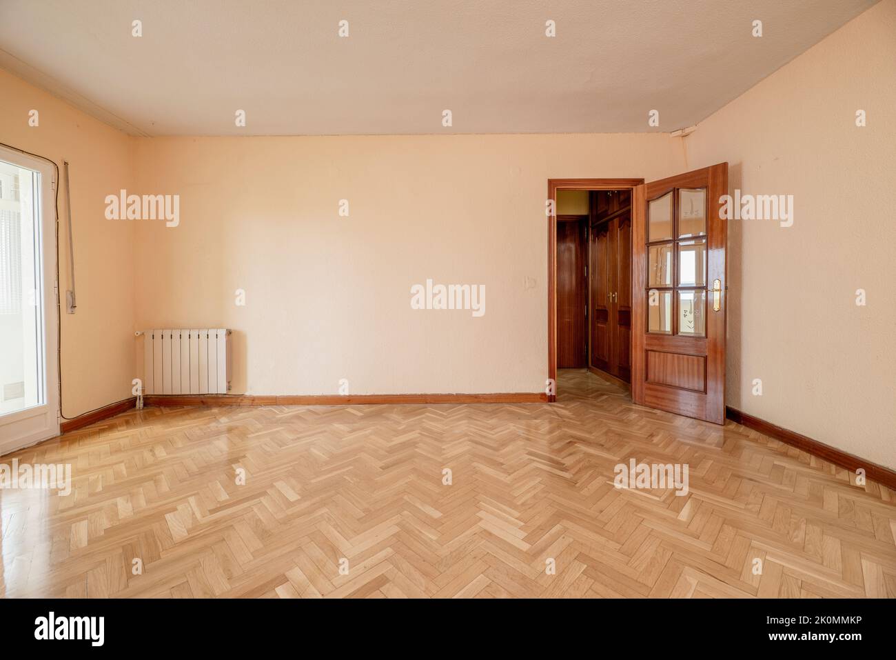 Empty room with white aluminum window, radiator in a niche, varnished ...