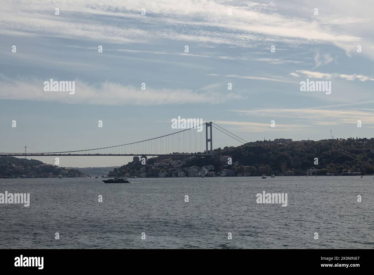 View of a yacht passing on Bosphorus. European side and FSM bridge are ...