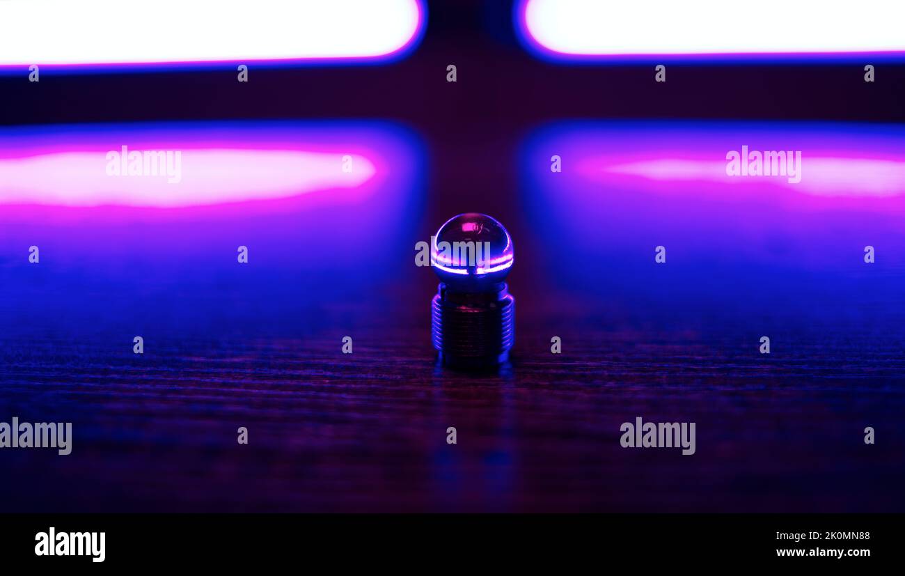 A glass ball on a wooden surface with purple lighting Stock Photo - Alamy