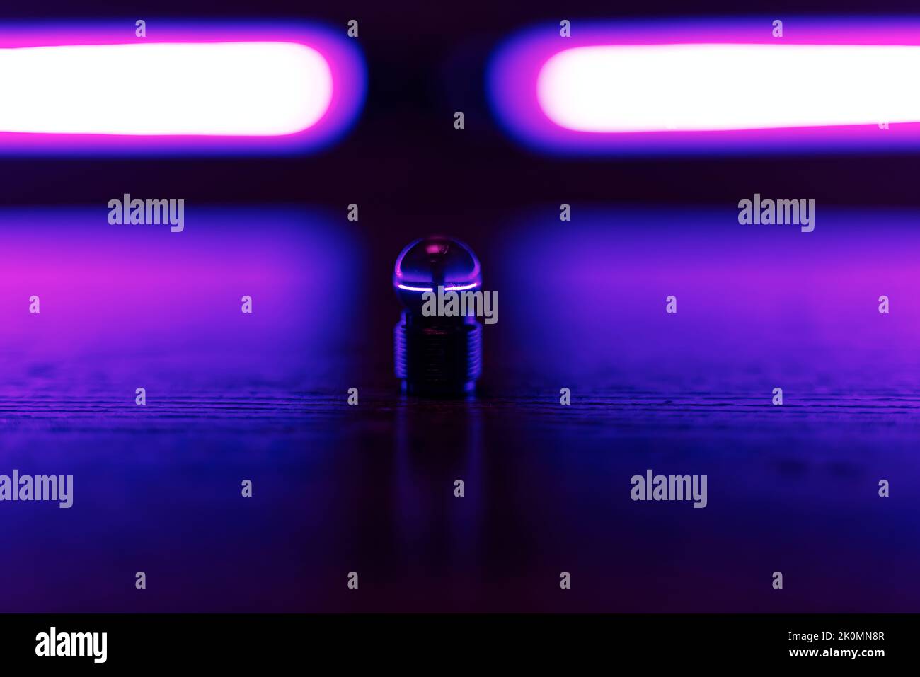 A glass ball on a wooden surface with purple lighting Stock Photo - Alamy