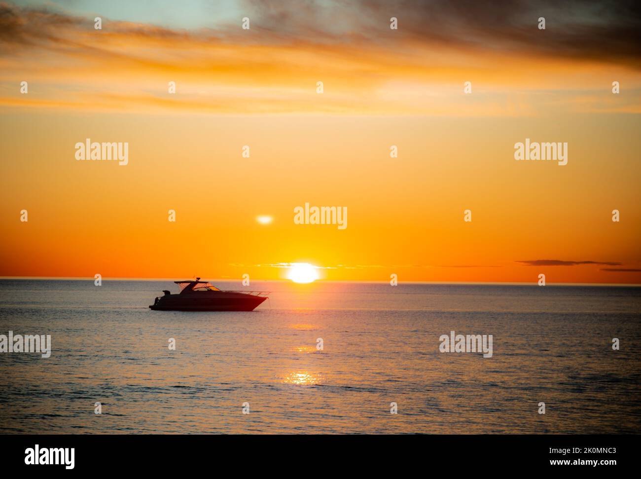 A beautiful view of a ship in a sea at sunset Stock Photo - Alamy