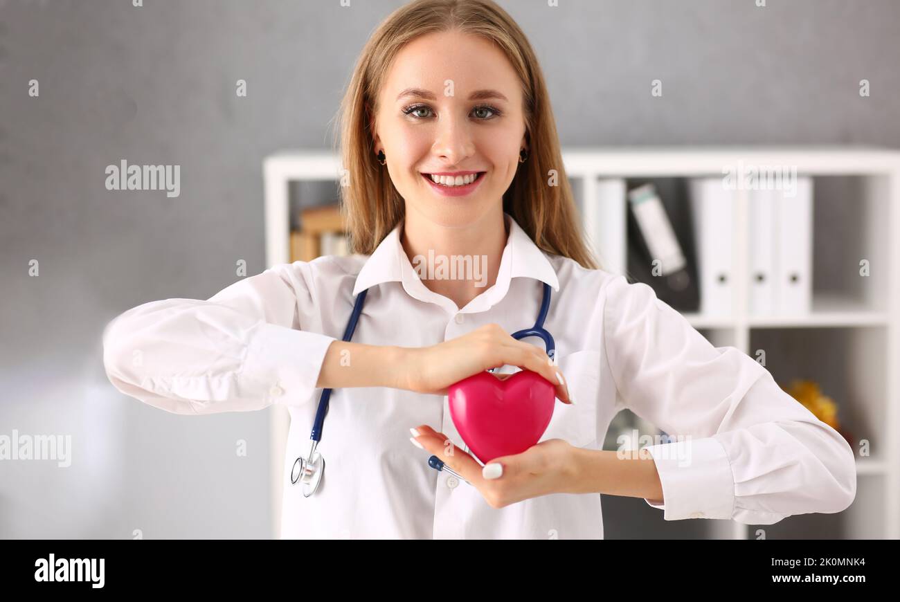 Cardiologist doctor holding red small heart in cardiology Stock Photo ...