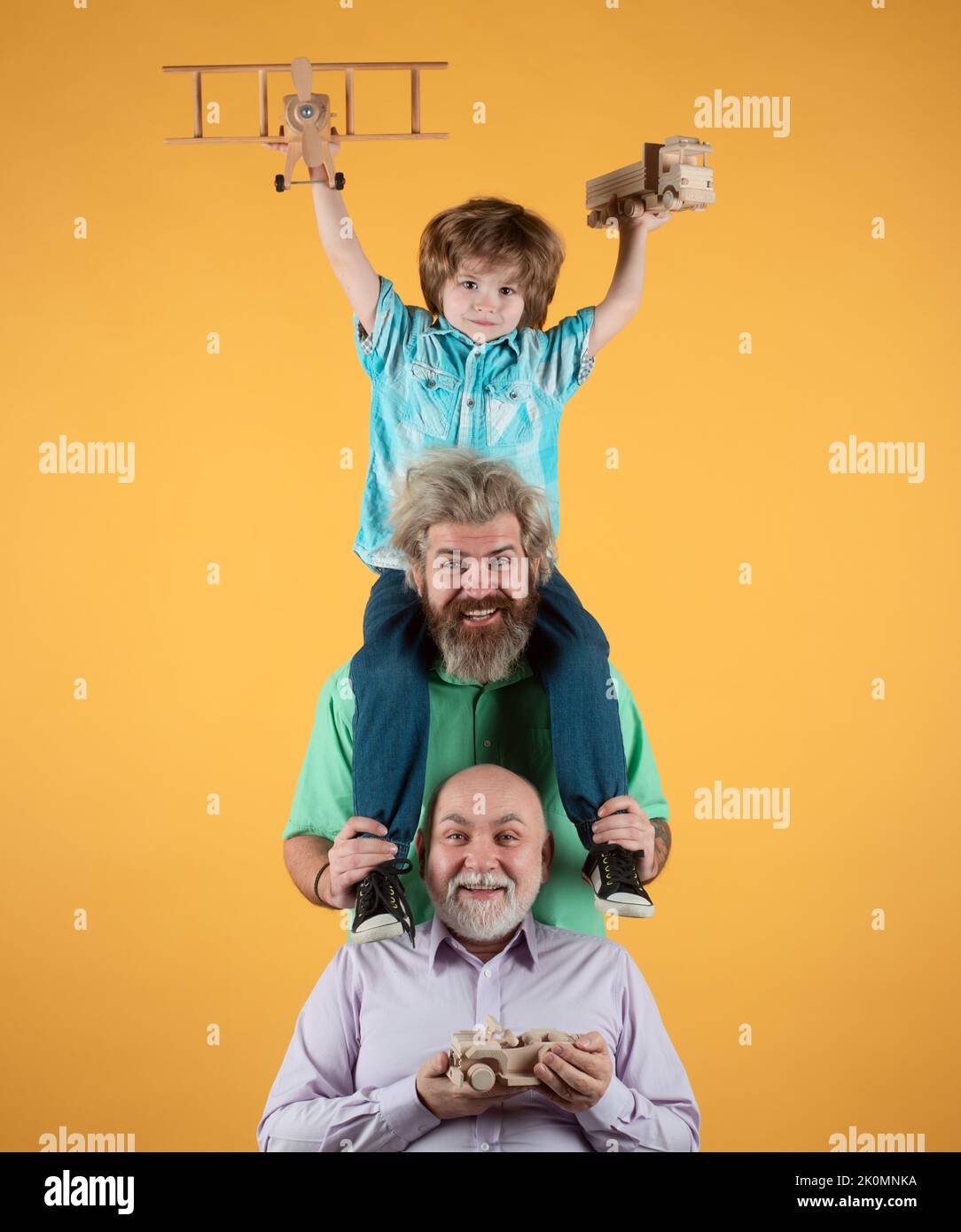 Kid having fun with toy plane. Men generation family with three ...