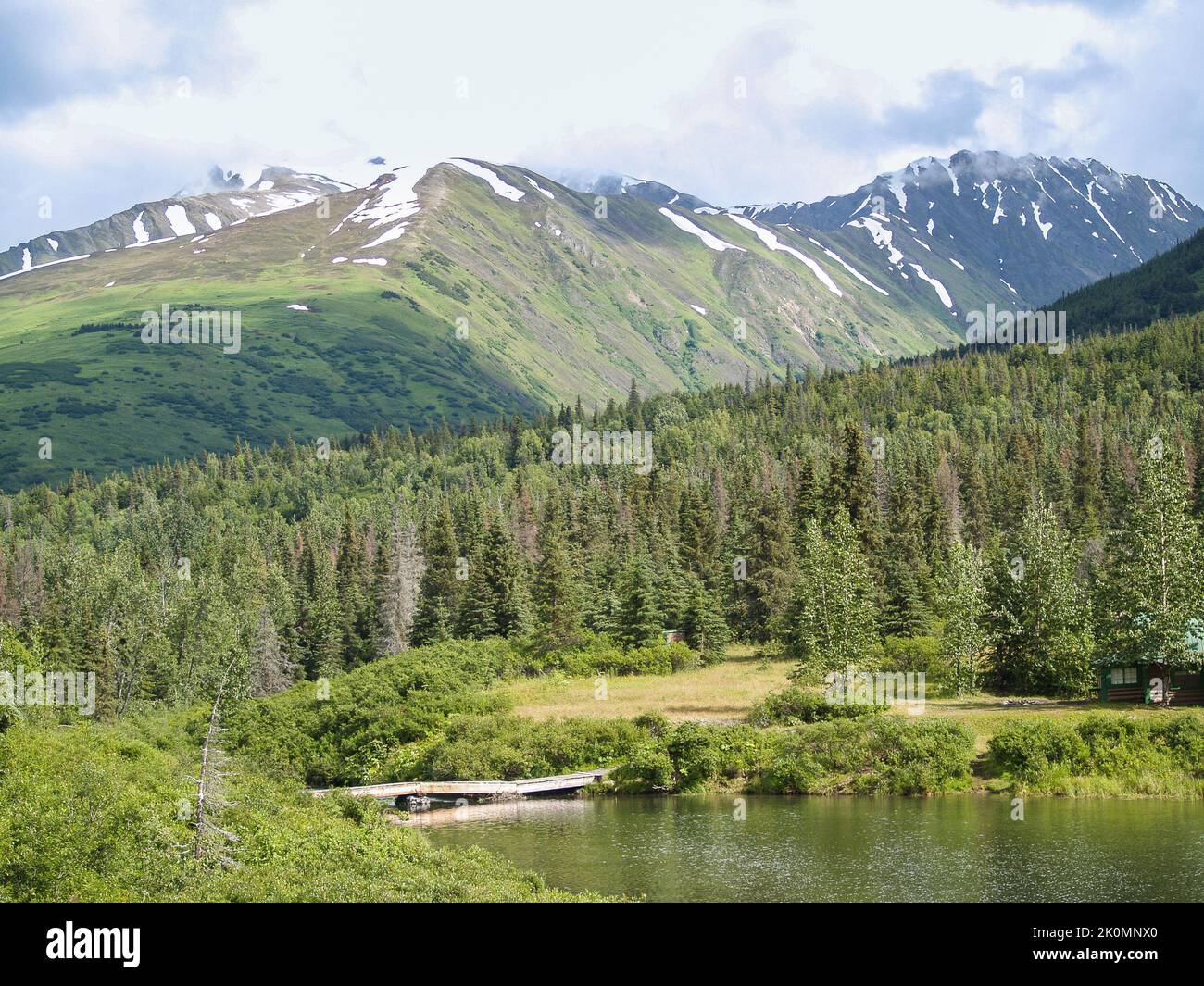 Alaskan wilderness and mountain landscape from small river to forest ...