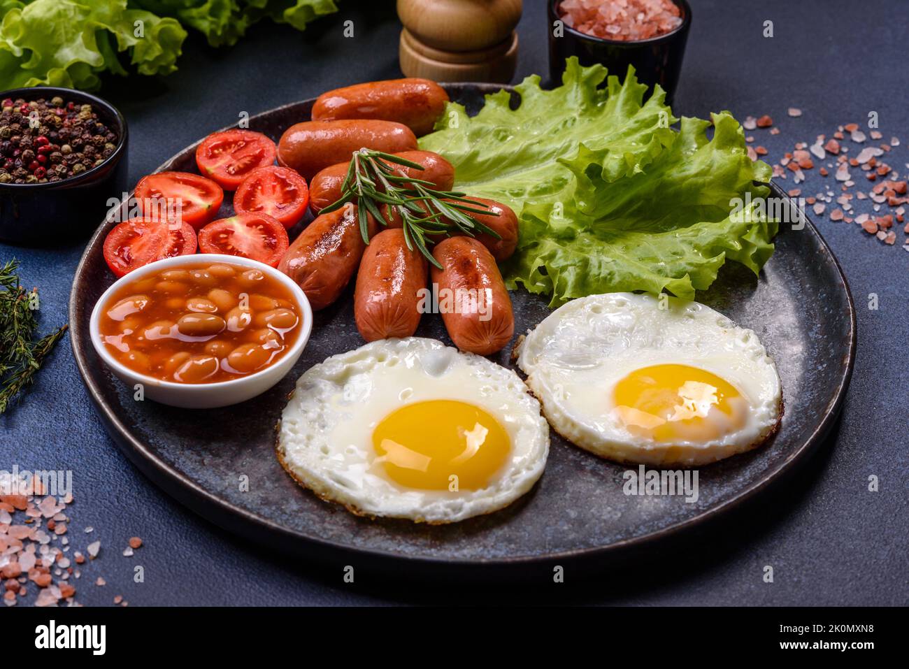 Traditional English breakfast with eggs, toast, sausages, beans, spices ...