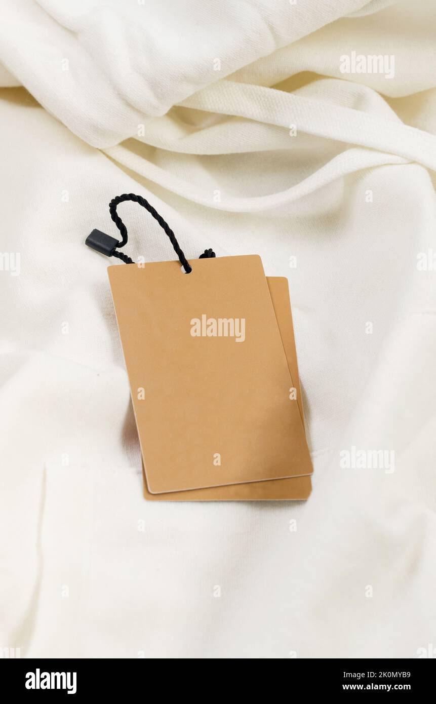 Empty brown cardboard tag with string on white jersey hoodie. Vintage ...
