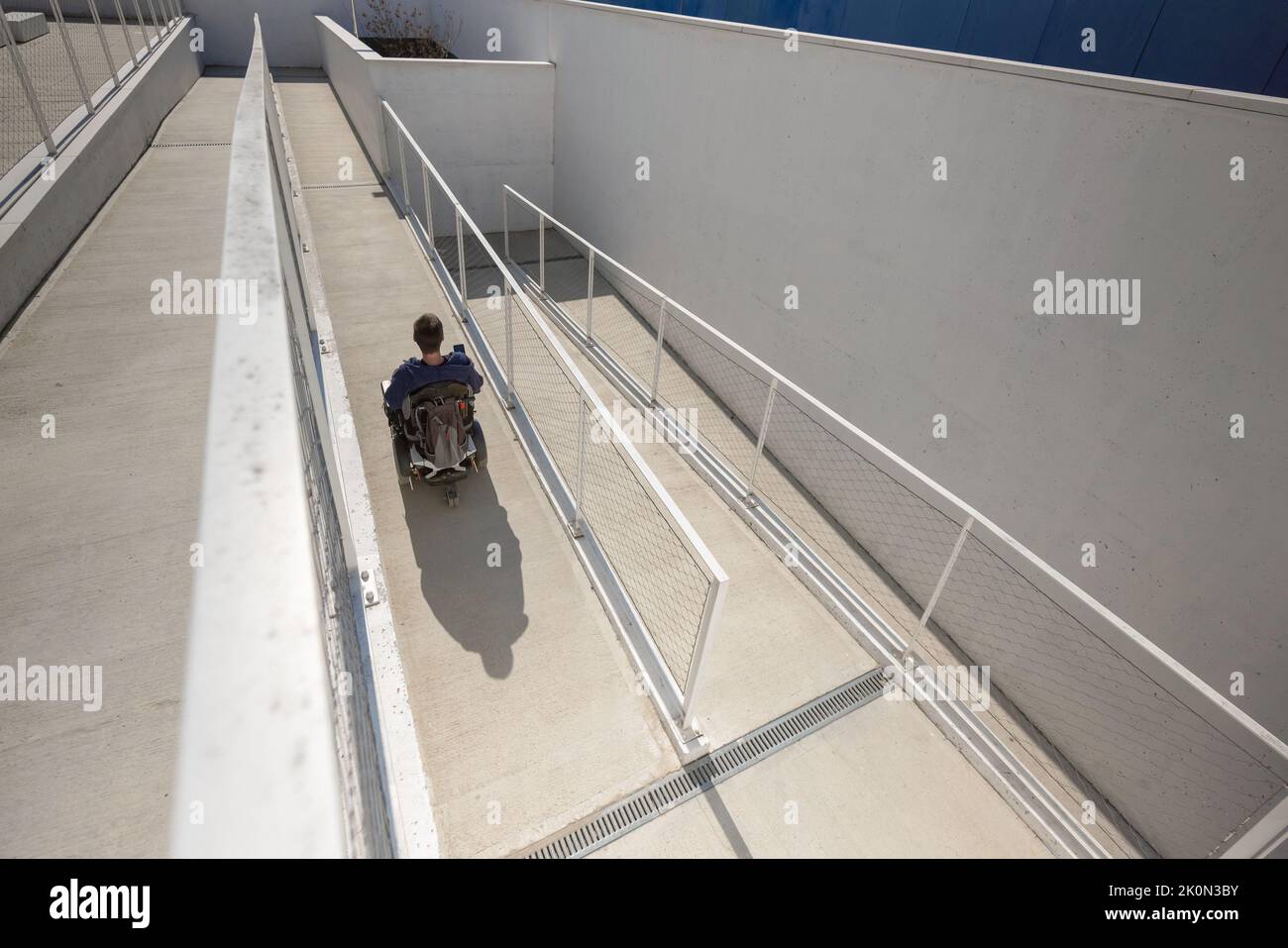 Man in a wheelchair use an accessible ramp Stock Photo - Alamy