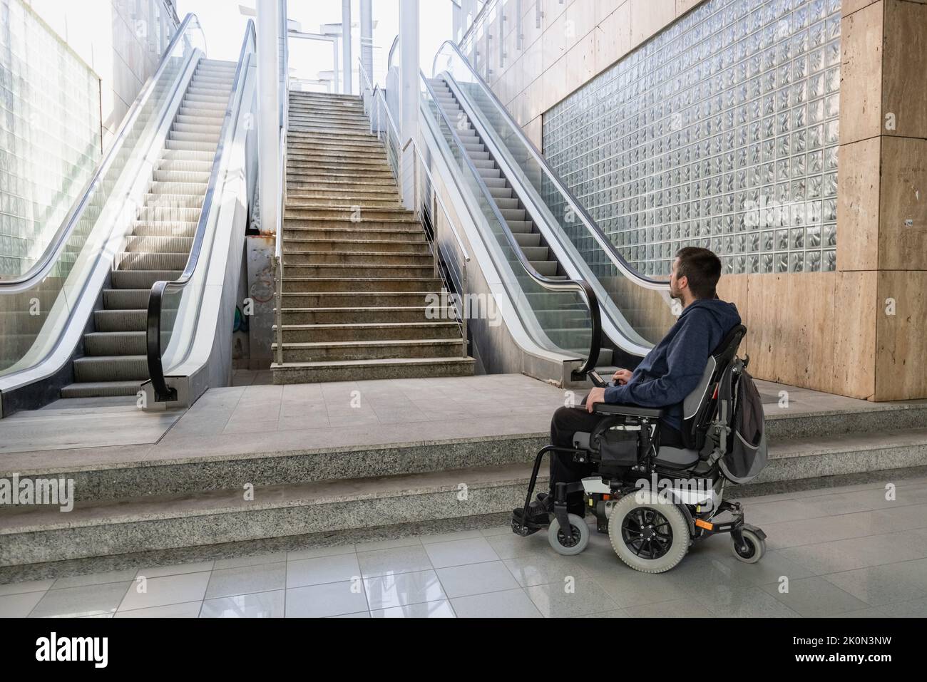 Man with disability on wheelchair stopped in front of staircase ...