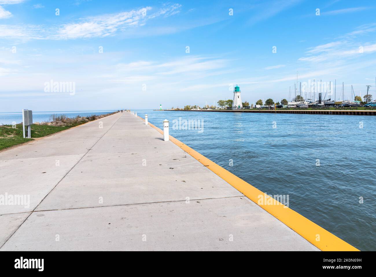 Concrete pier at the entrance of a harbour on a clear autumn day. Two ...