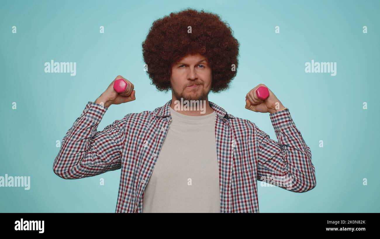 Working out pumping up arm muscles lifting blue dumbbells, practicing ...