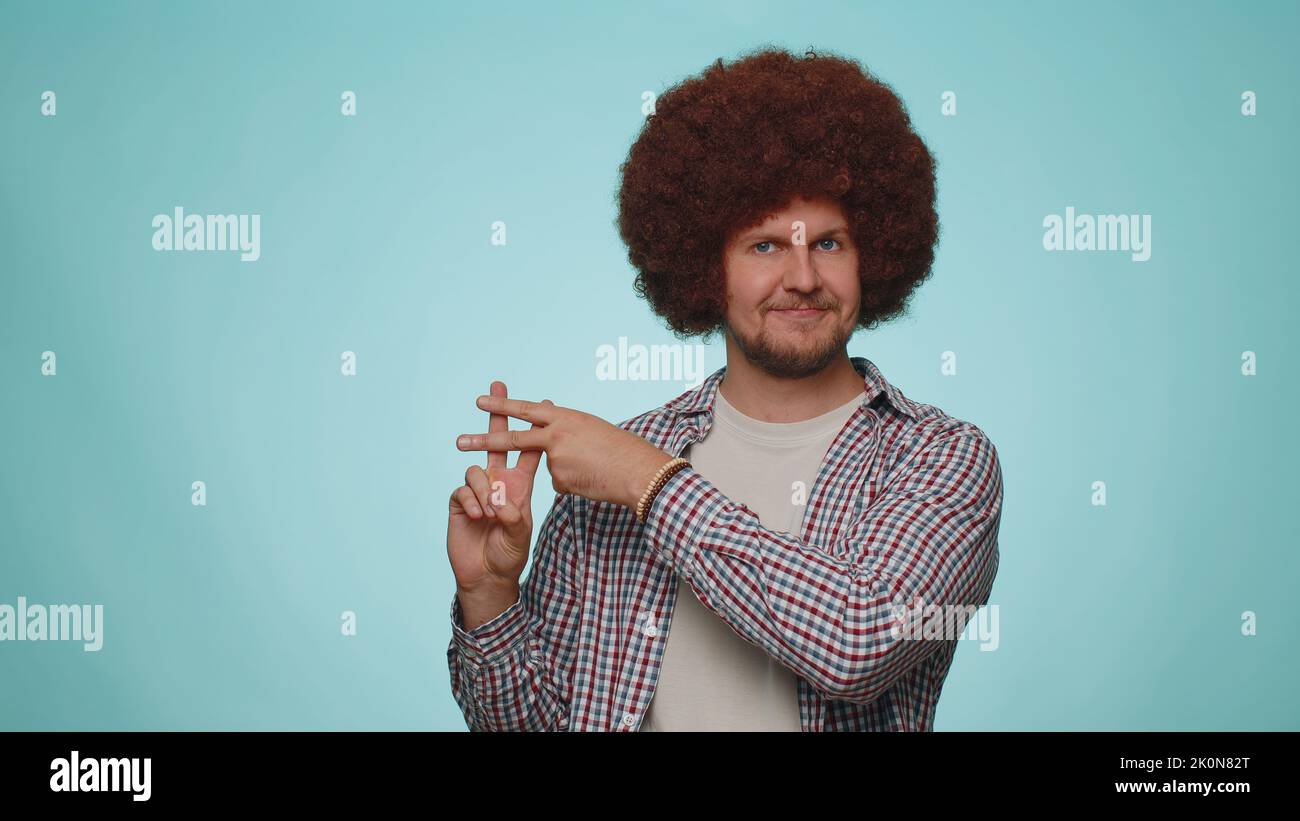 Cheerful bearded man showing hashtag symbol with hands, likes tagged ...