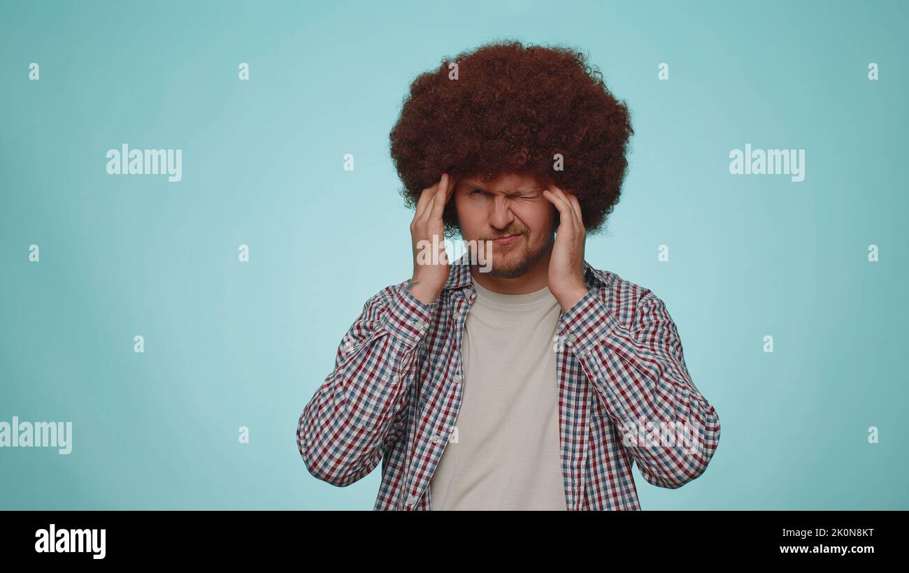 Bearded young adult man in shirt rubbing temples to cure headache ...