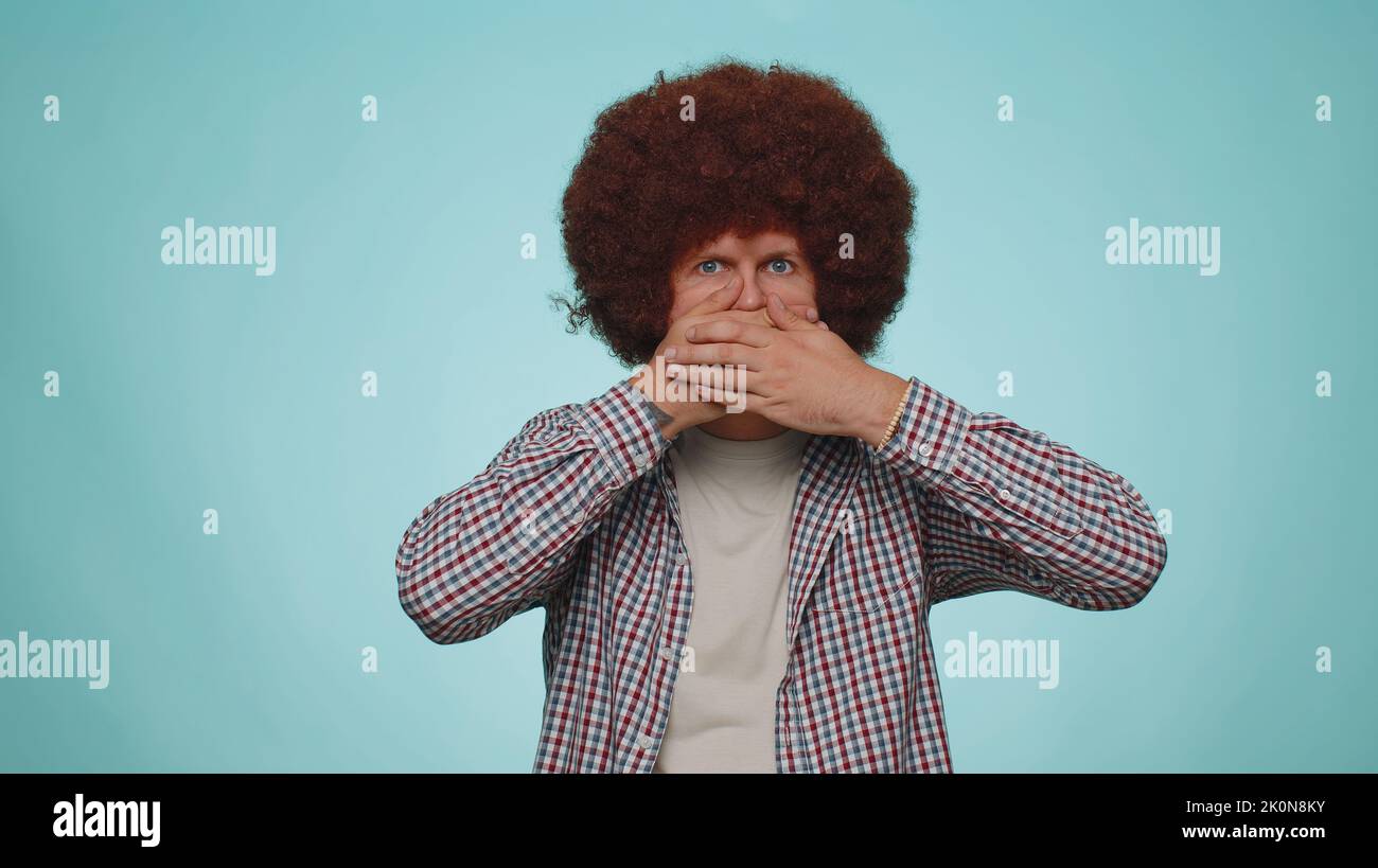 I will not say anyone. Frightened sincere man closing his mouth with ...