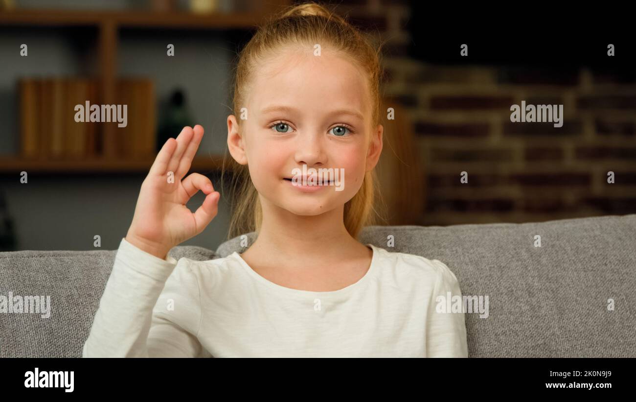 Portrait of caucasian happy child girl smiling kid sitting on sofa at ... Portrait of caucasian happy child girl smiling kid sitting on sofa at ...